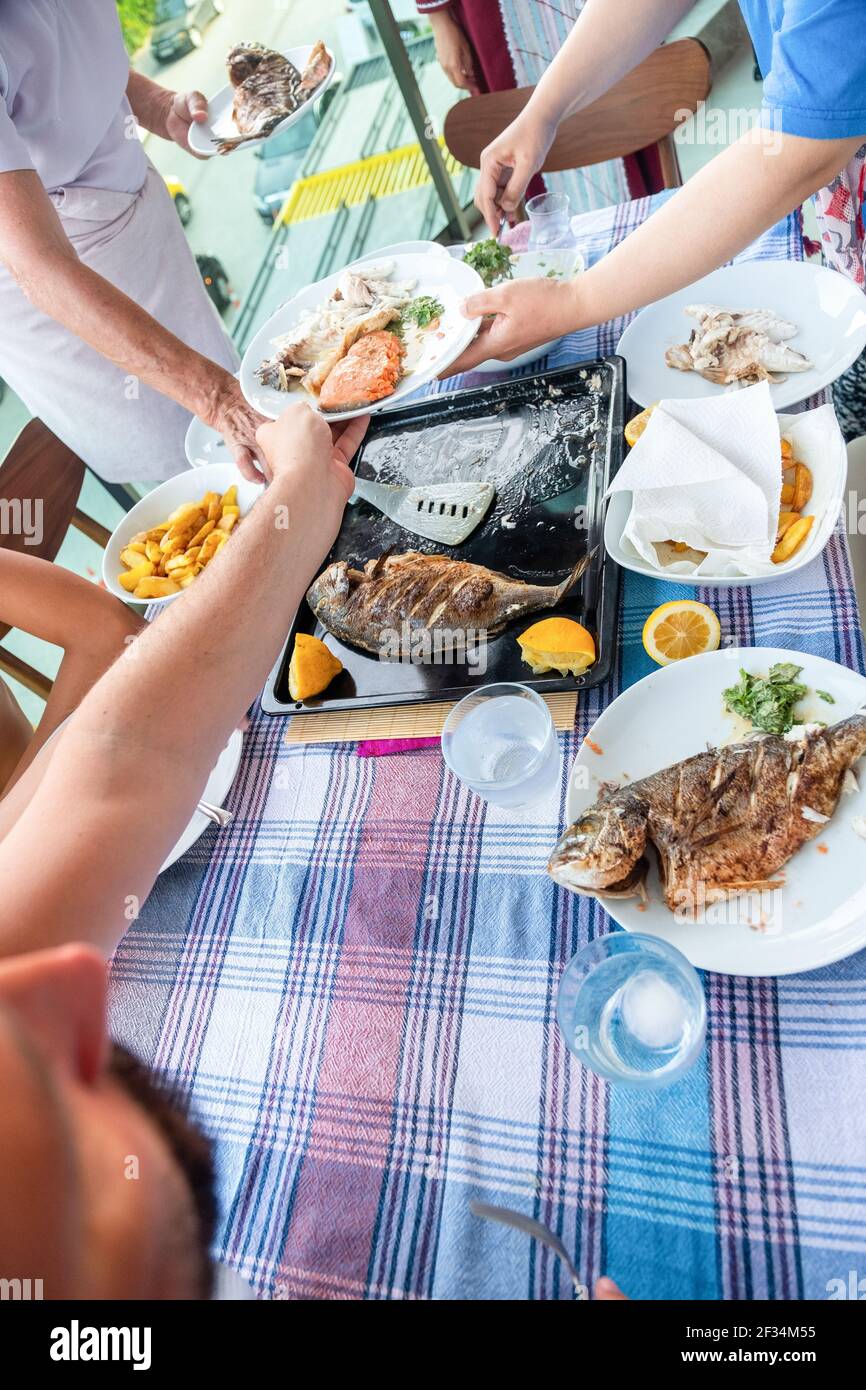 Family gathering to eat fish together Stock Photo - Alamy