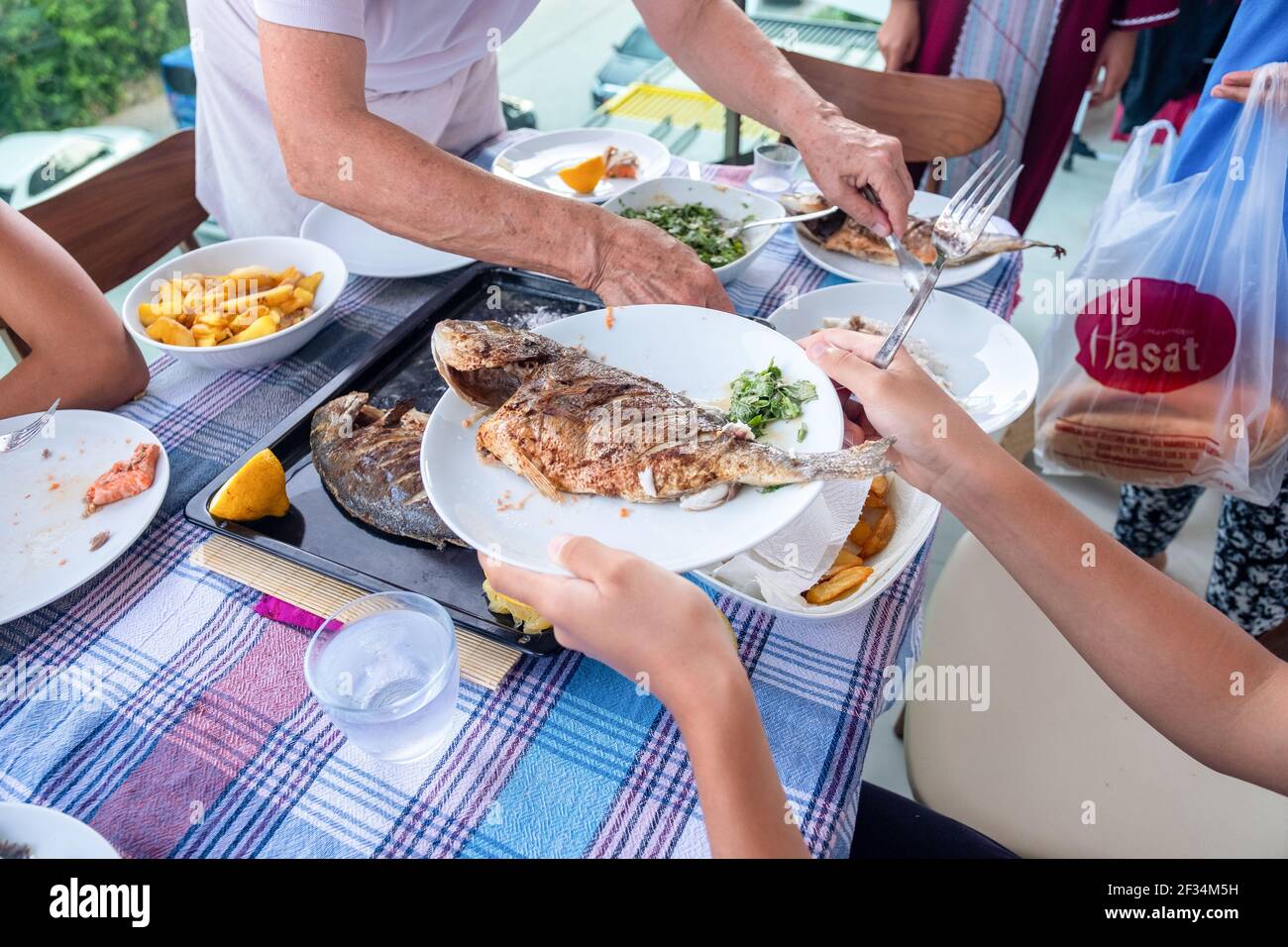 Family gathering to eat fish together Stock Photo - Alamy