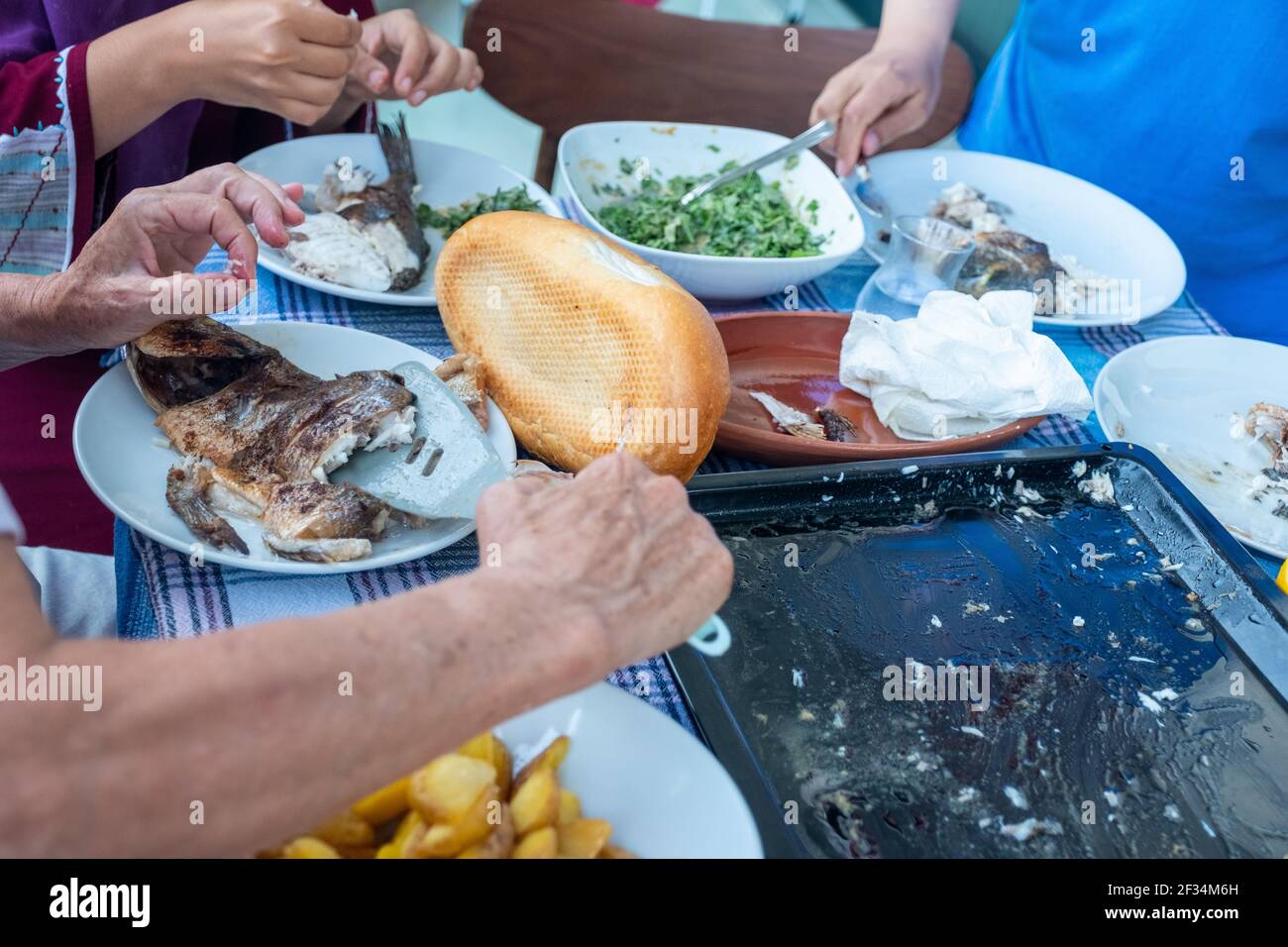 Family gathering to eat fish together Stock Photo - Alamy