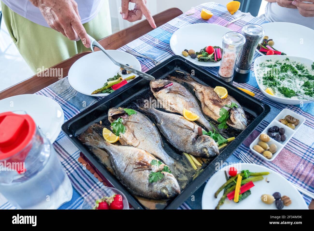 Family gathering to eat fish together Stock Photo - Alamy