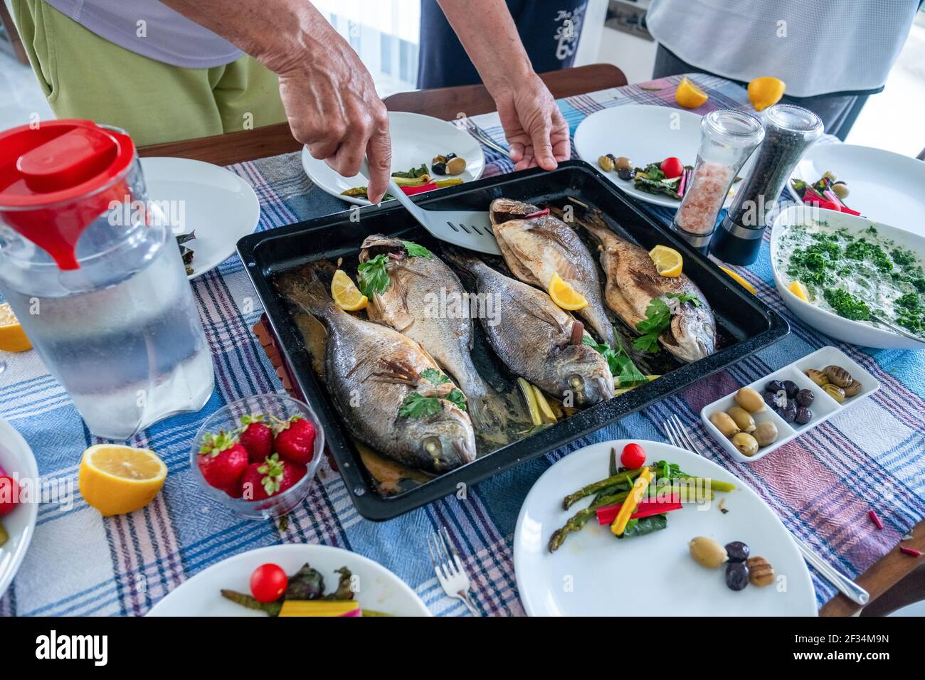 Family gathering to eat fish together Stock Photo - Alamy