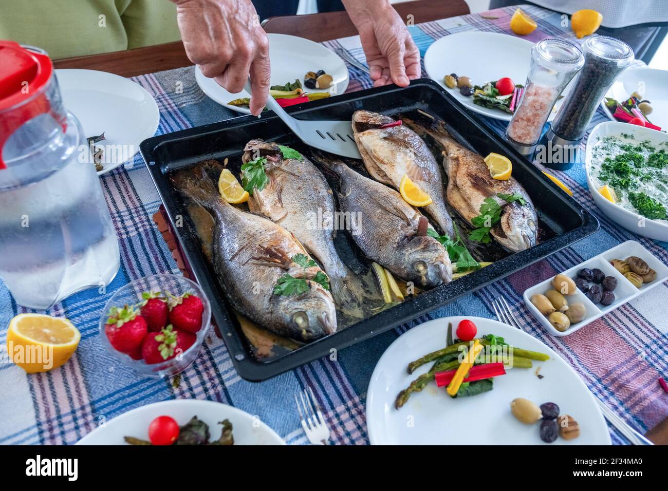 Family gathering to eat fish together Stock Photo - Alamy