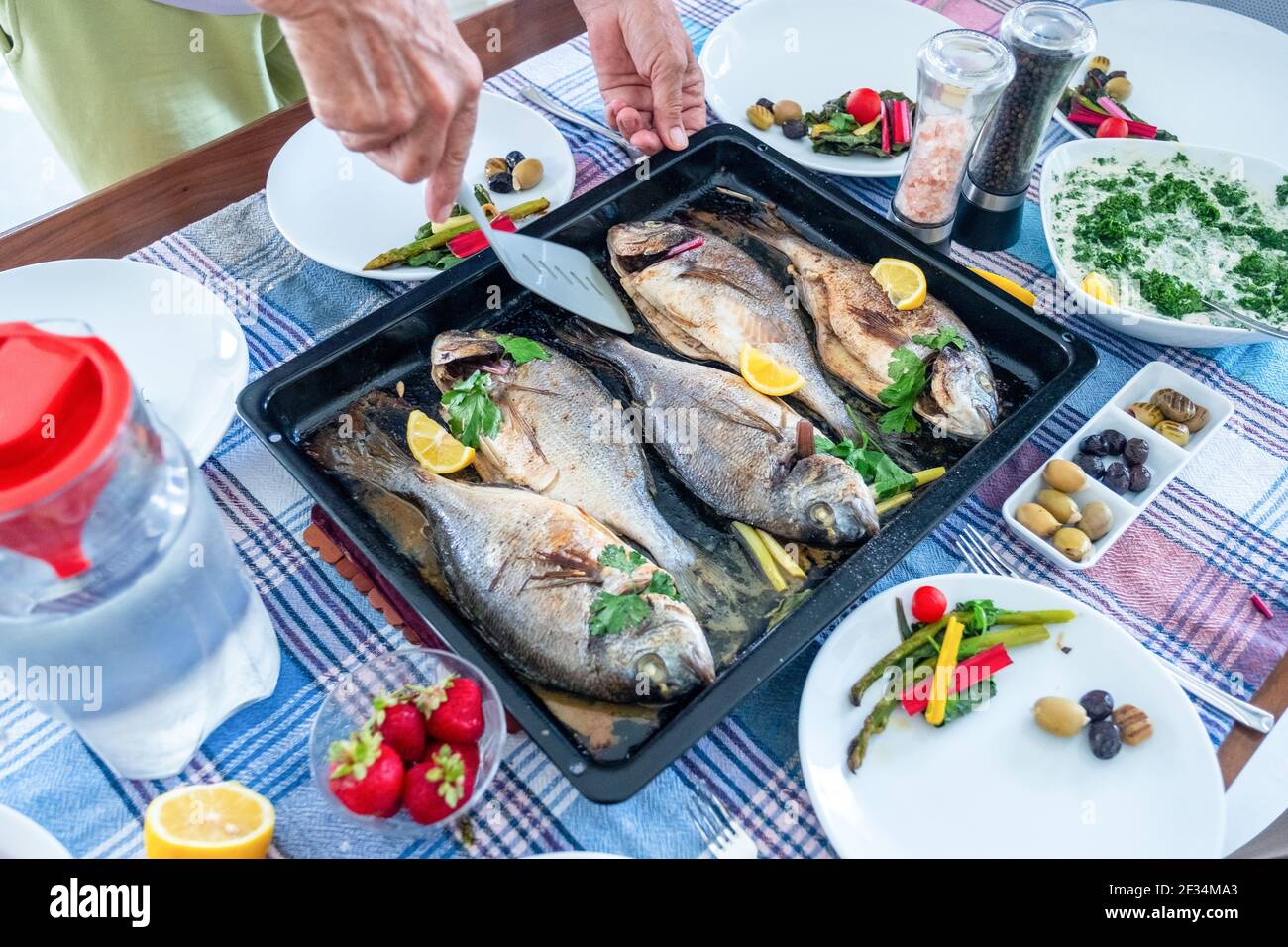 Family gathering to eat fish together Stock Photo - Alamy