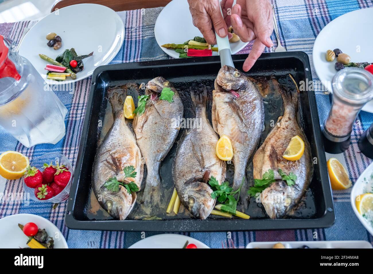 Family gathering to eat fish together Stock Photo - Alamy
