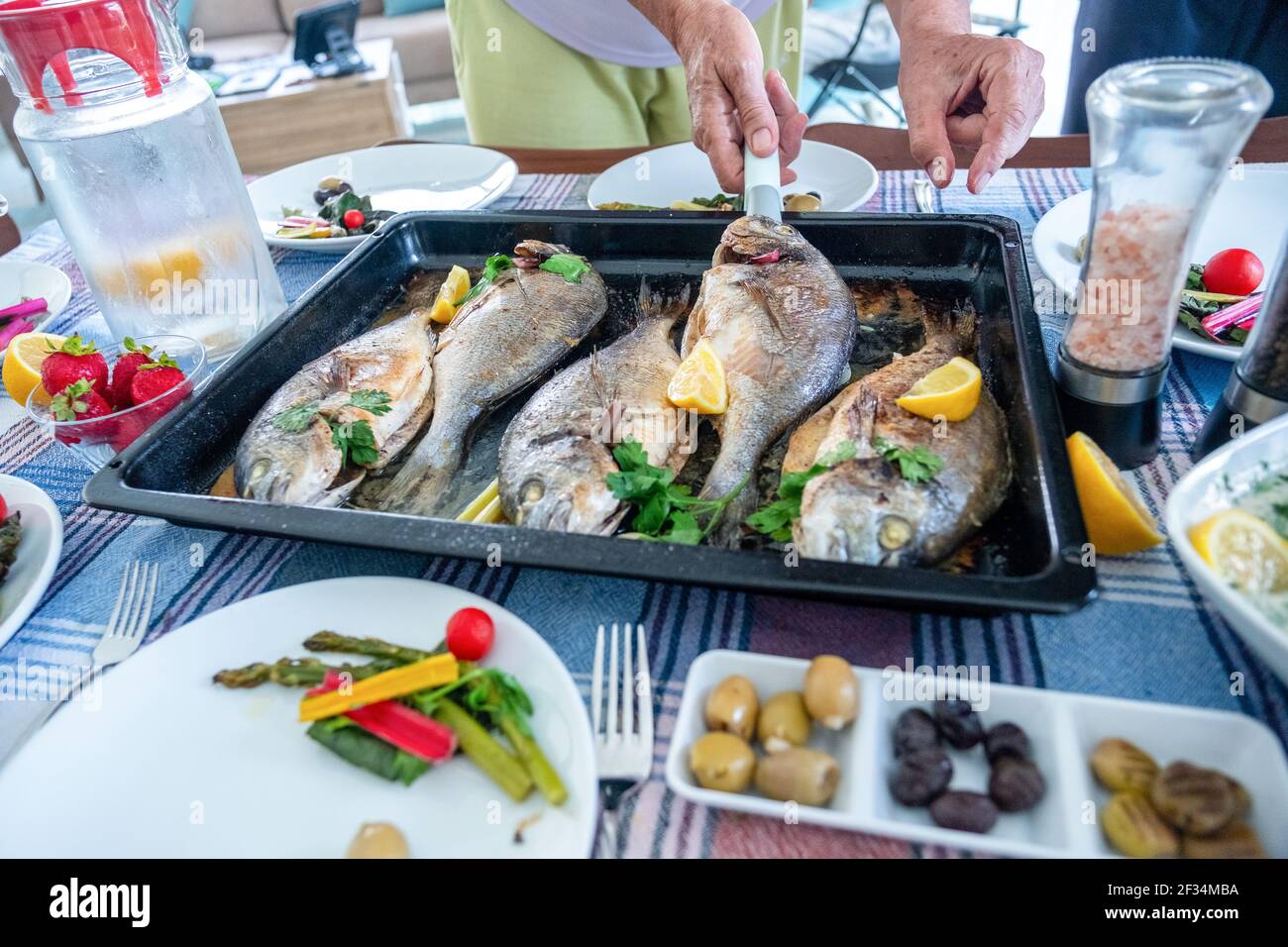 Family gathering to eat fish together Stock Photo - Alamy