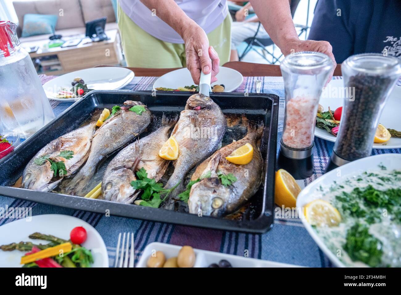 Family gathering to eat fish together Stock Photo - Alamy