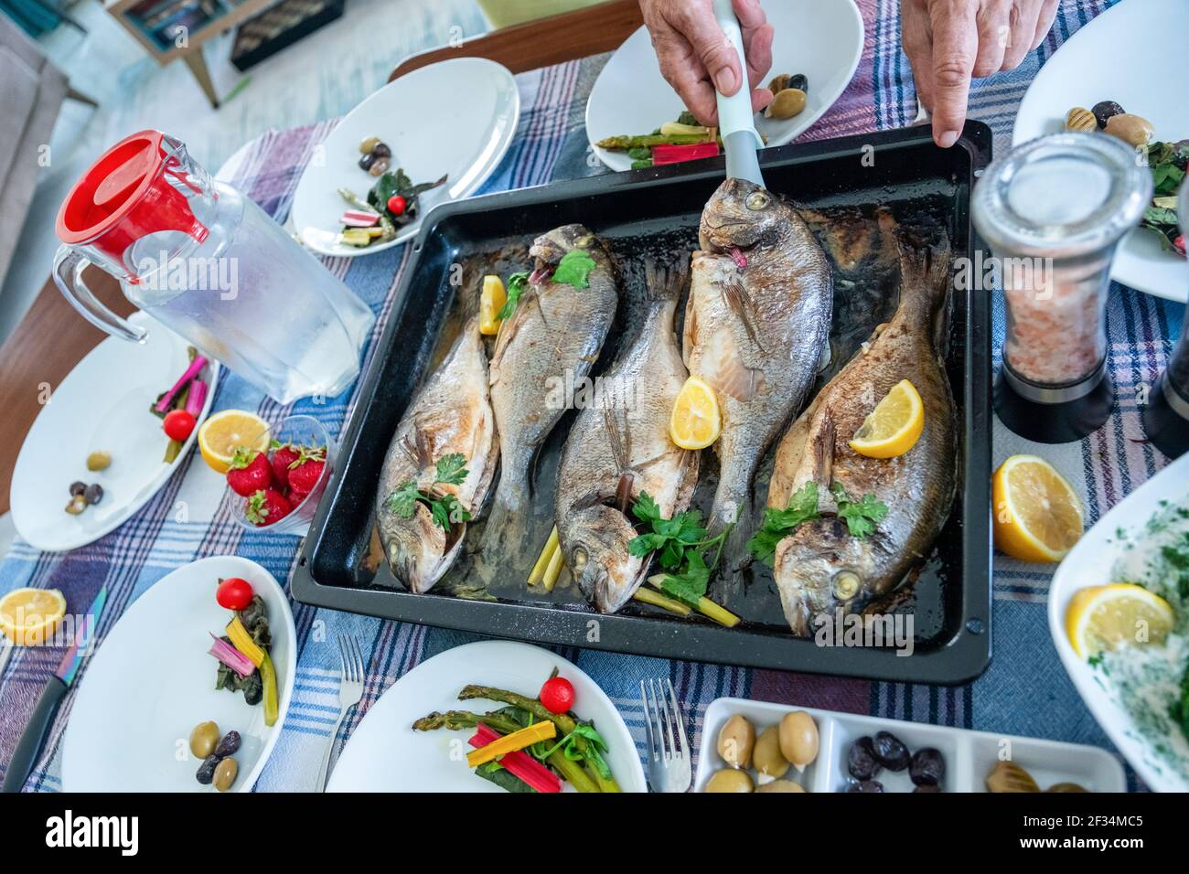 Family gathering to eat fish together Stock Photo - Alamy
