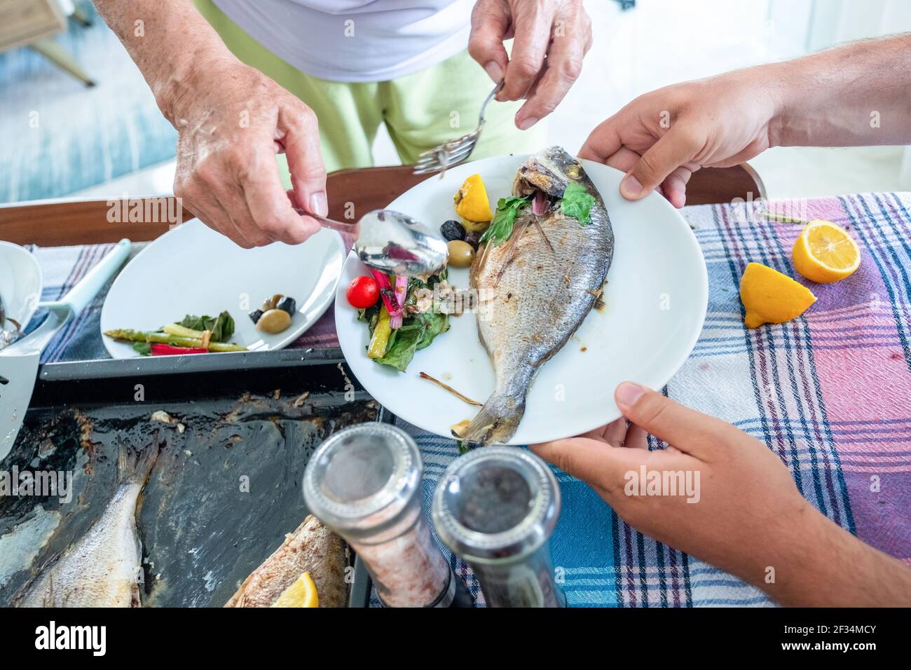 Family gathering to eat fish together Stock Photo - Alamy
