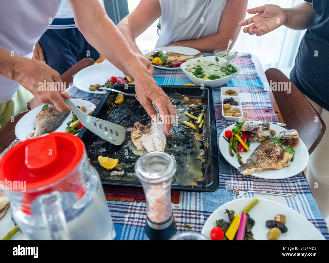 Family gathering to eat fish together Stock Photo - Alamy