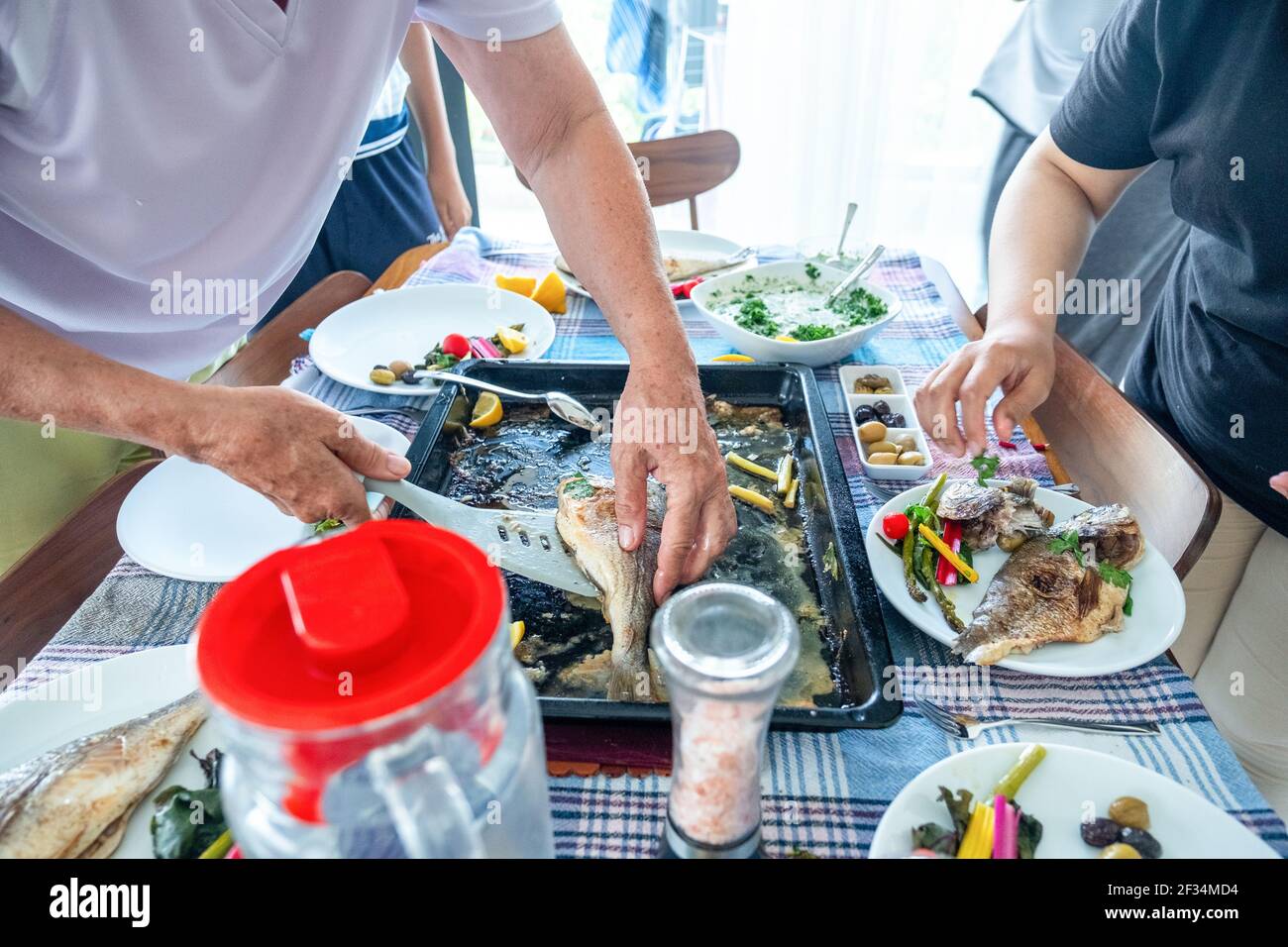 Family gathering to eat fish together Stock Photo - Alamy