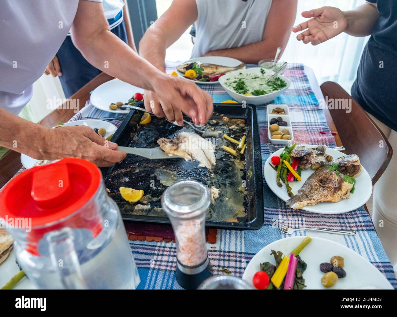 Family gathering to eat fish together Stock Photo - Alamy