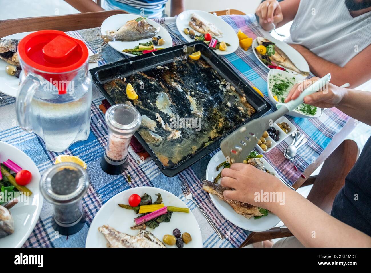 Family gathering to eat fish together Stock Photo - Alamy