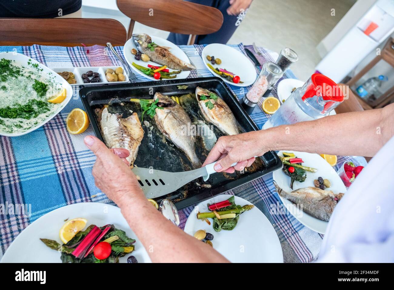 Family gathering to eat fish together Stock Photo - Alamy