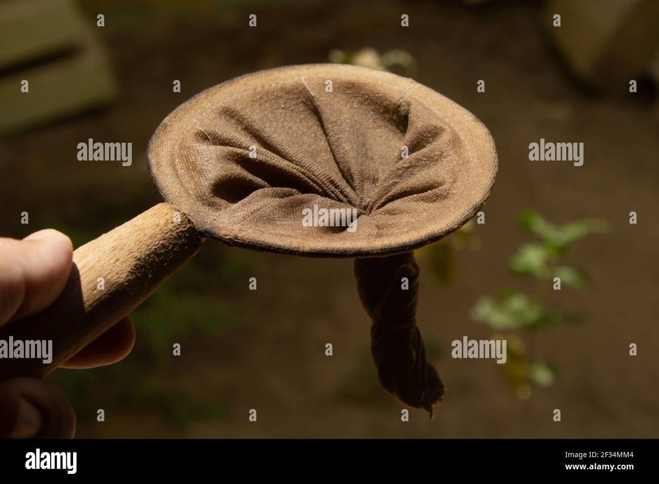 A hand holding a coffee strainer Stock Photo - Alamy