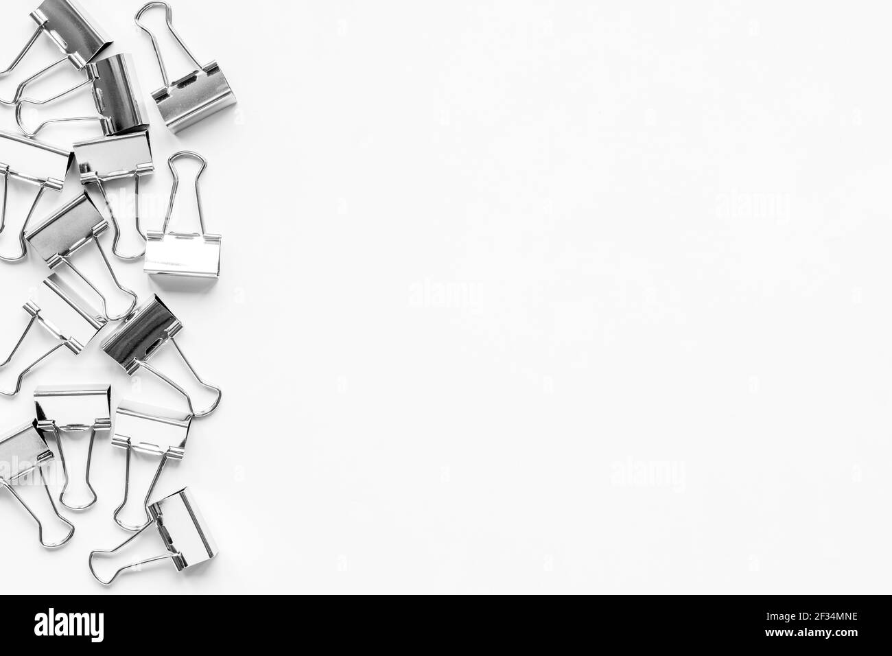 Stationery and office supplies background. Paper binder clips top view ...