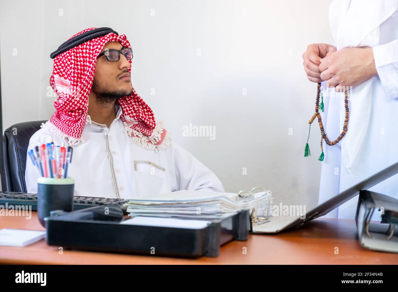 Arabic Muslim employee talking to his boss at work Stock Photo - Alamy