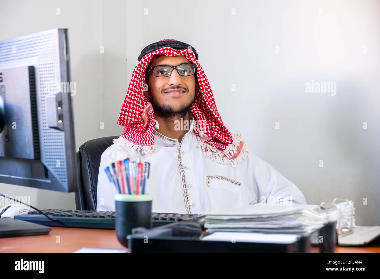 Arabic muslim employee happy at his workplace Stock Photo - Alamy