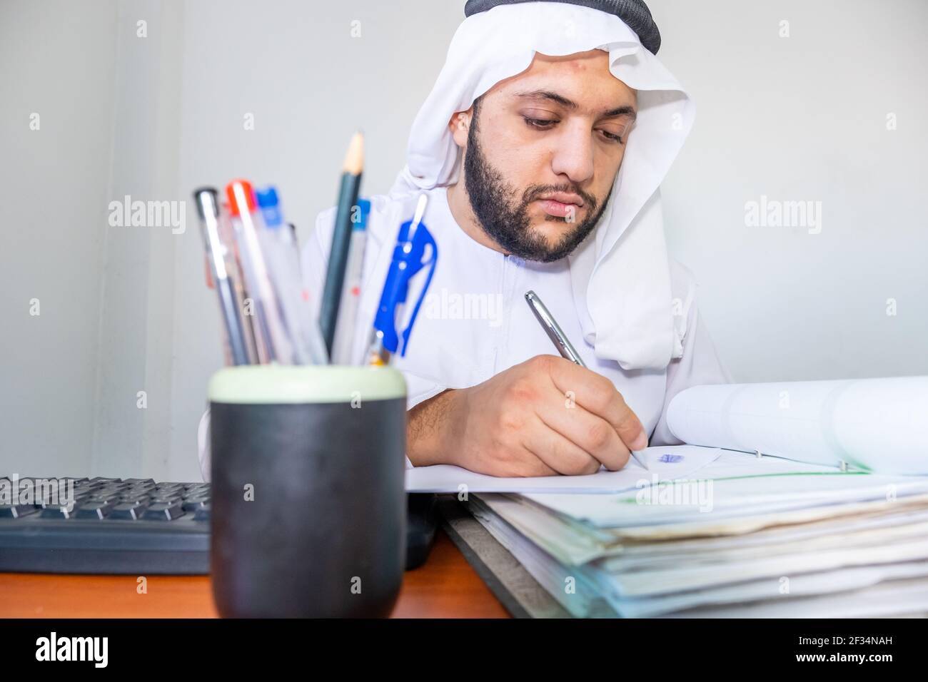 Arabic Muslim man working on some paper Stock Photo - Alamy