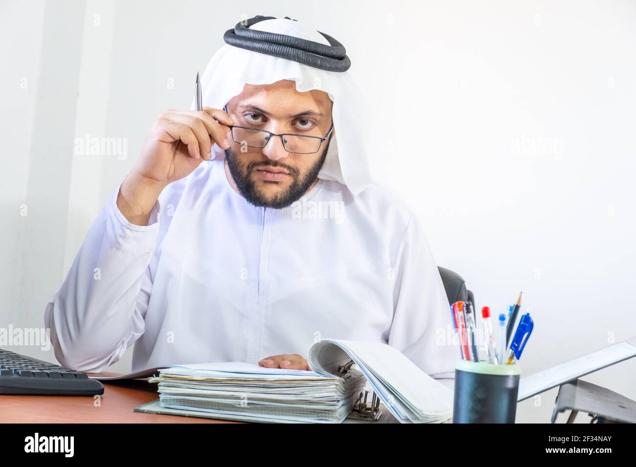 Arabic Muslim man at work holding his eyeglasses Stock Photo - Alamy
