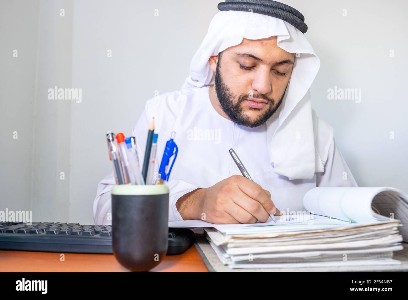 Arabic Muslim man working on some paper Stock Photo - Alamy