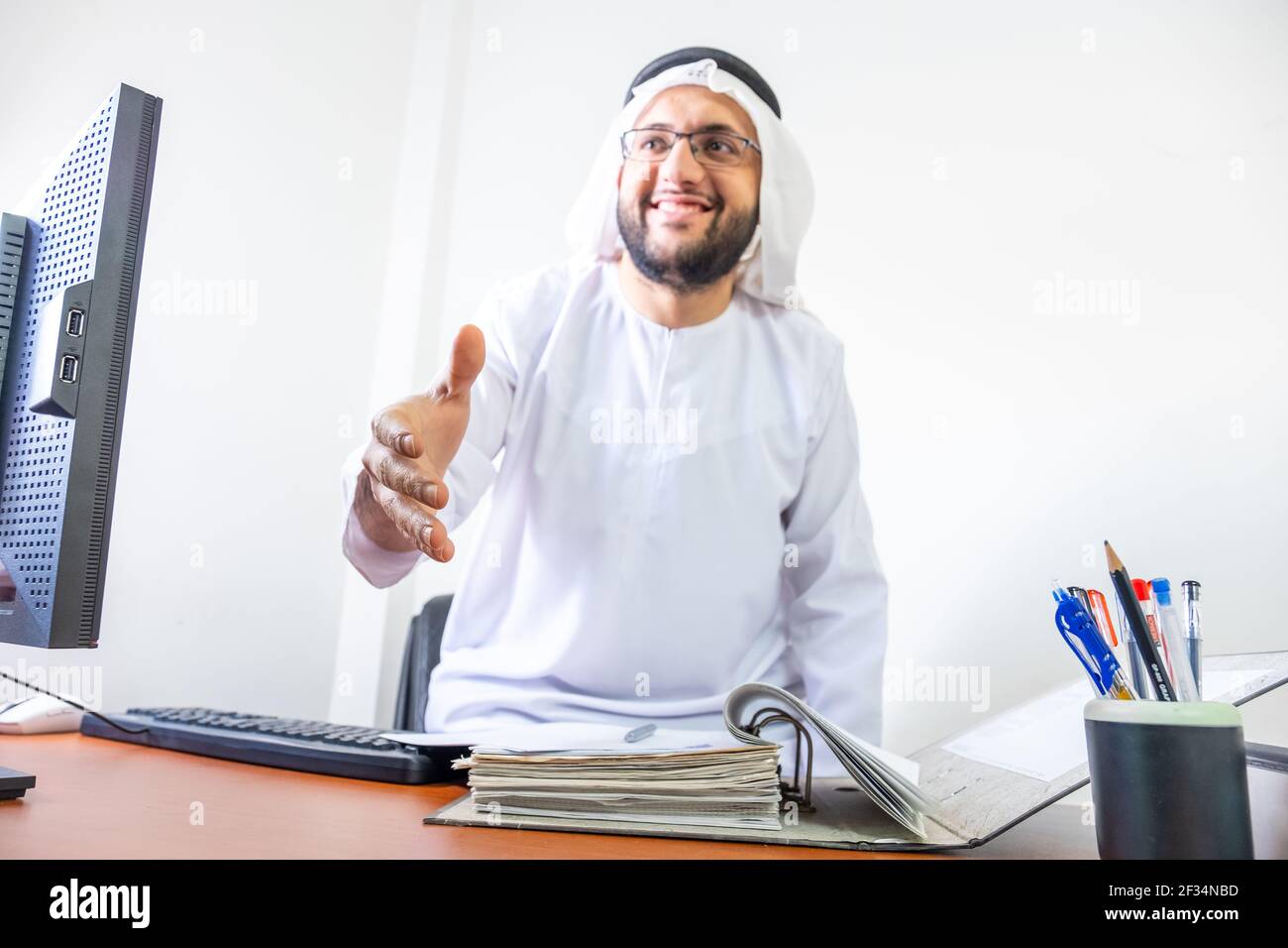 Arabic Muslim manager standing to welcome his guest Stock Photo - Alamy