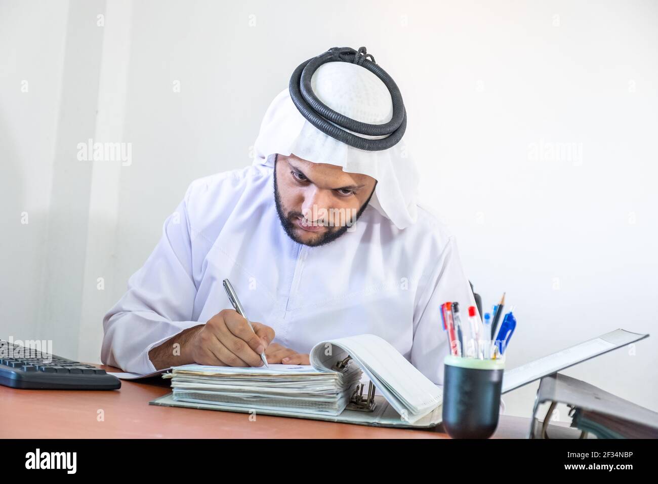 Arabic Muslim man working on some paper Stock Photo - Alamy