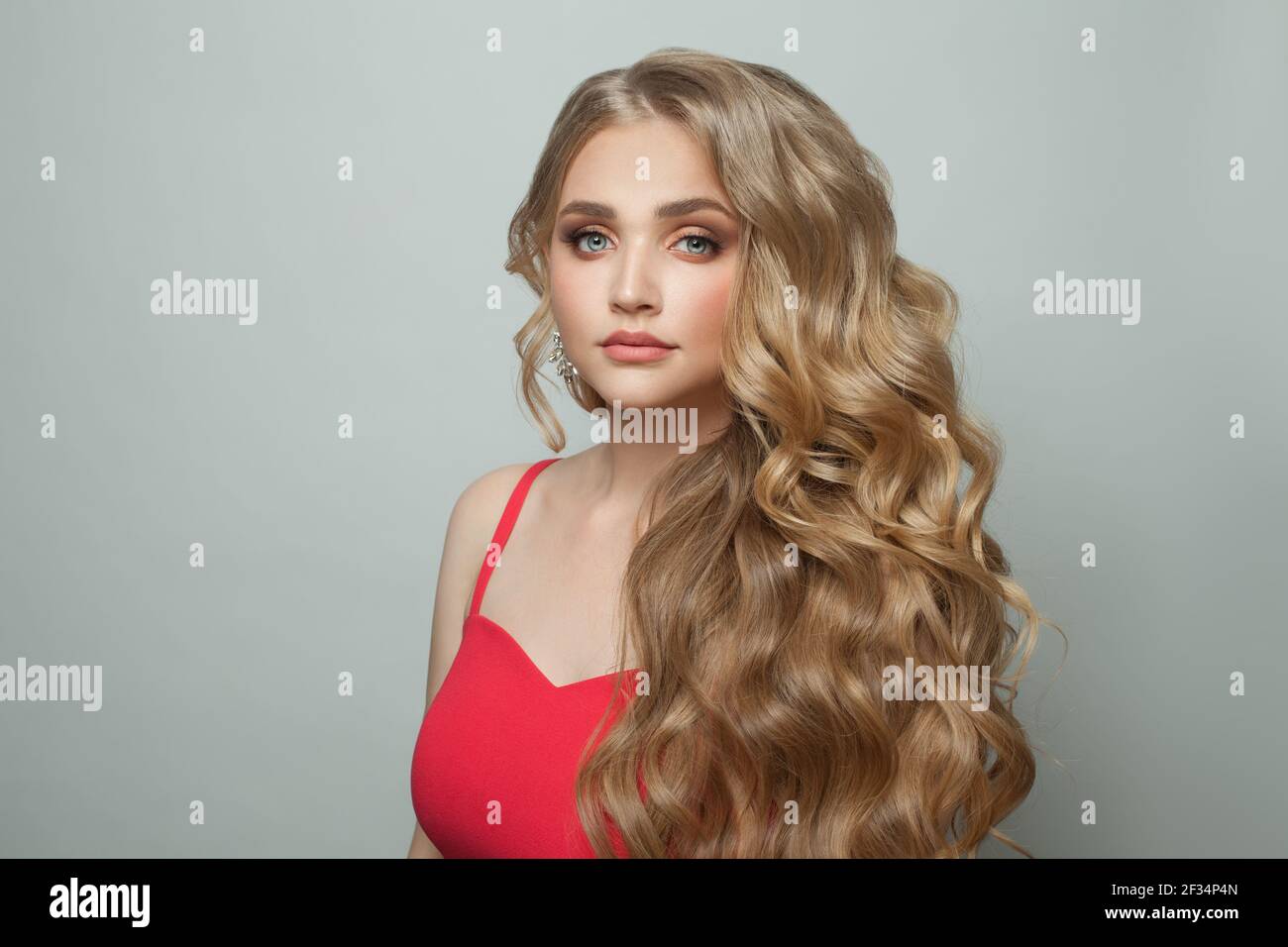 Young beautiful blonde woman with long perfect hair on white background ...