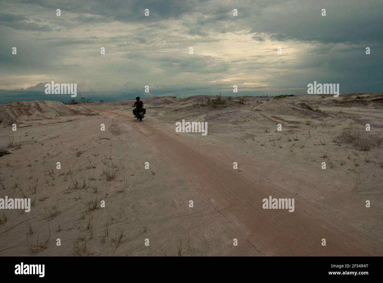Workers of a traditional gold mining team riding motorcycle to reach a ...
