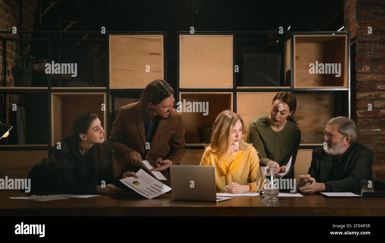 Paperwork. Young colleagues working together in a office styled like ...