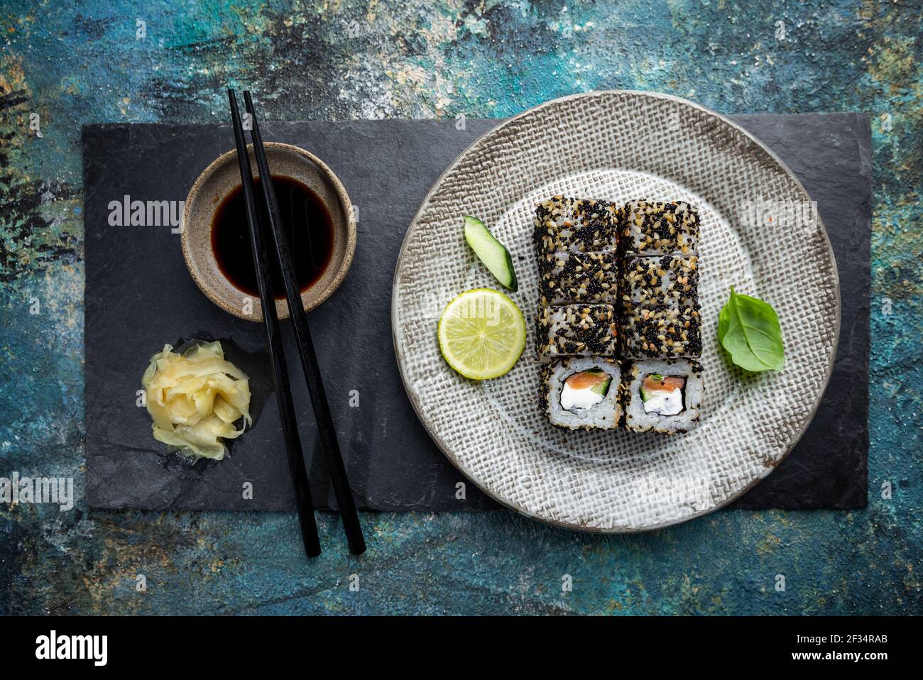 Set of sushi and maki with soy sauce over blue stone background. Top ...