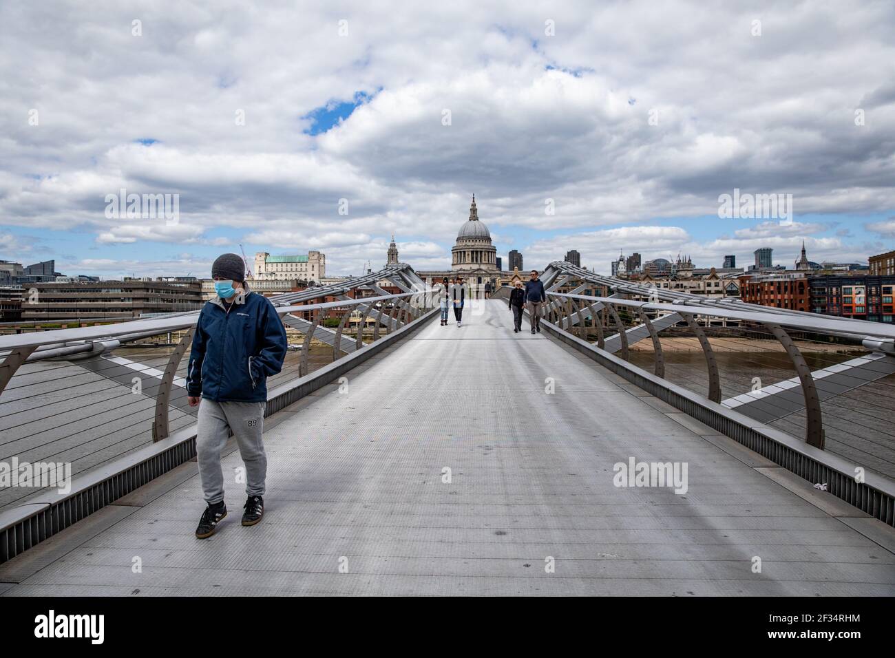 Members of the public walk over Millennium Bridge in Central London ...
