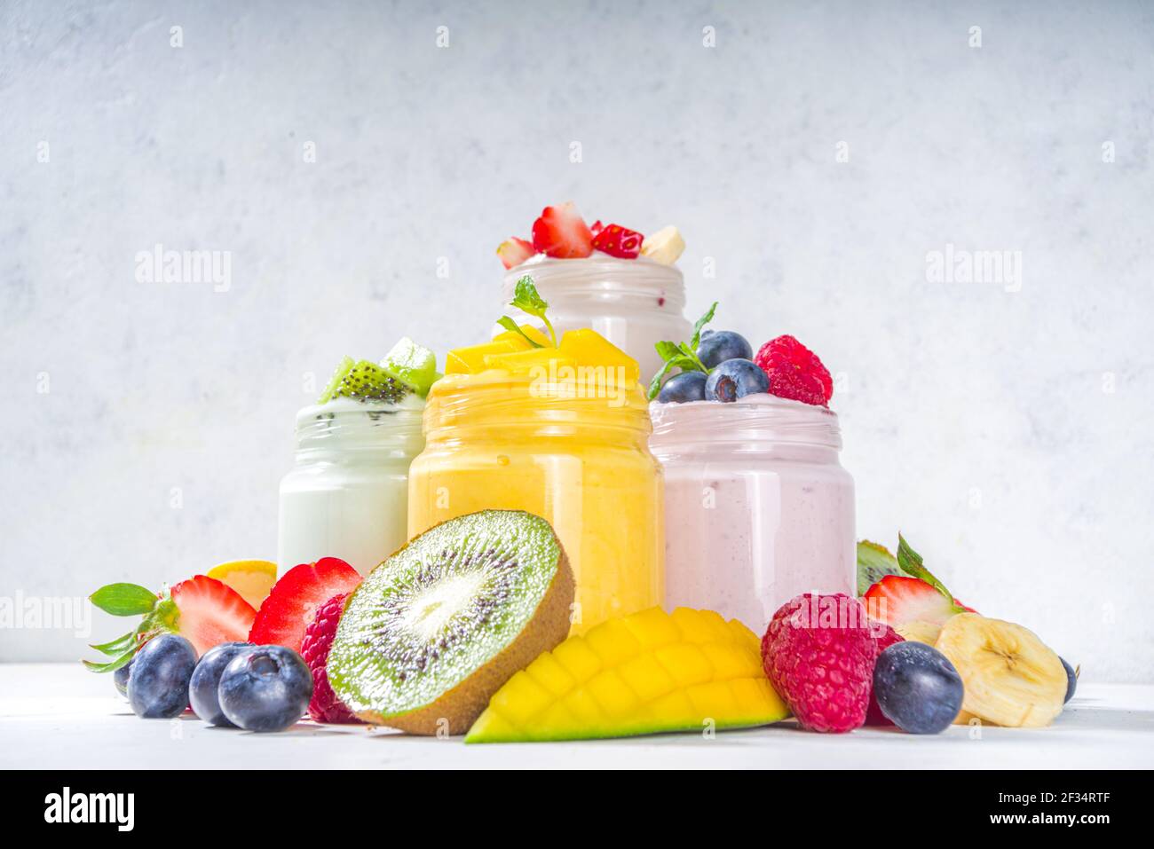 Set of various fruit and berry sweet yogurts in glass jars. Variety ...