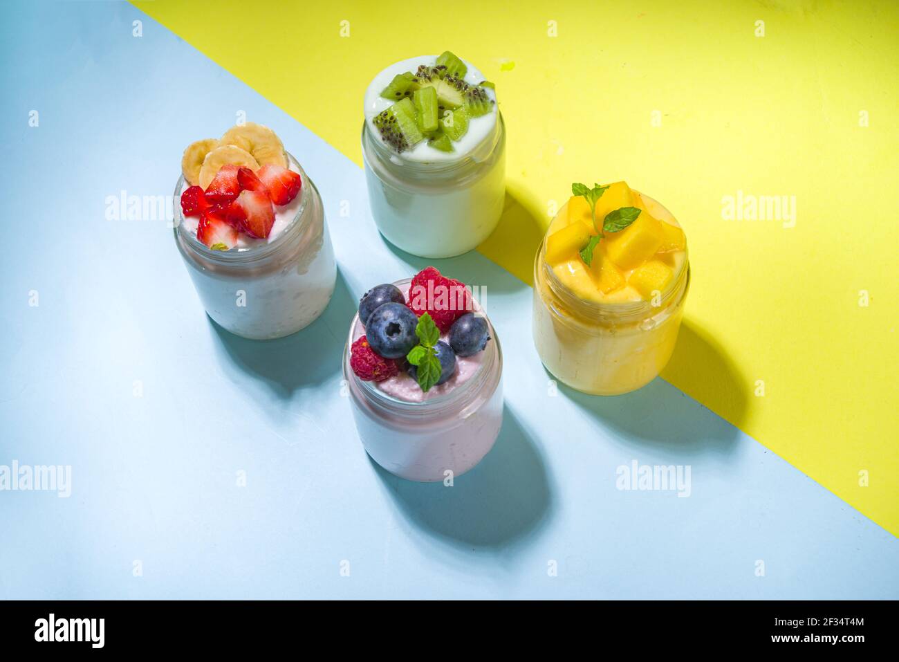 Set of various fruit and berry yogurts in glass jars. Variety healthy ...