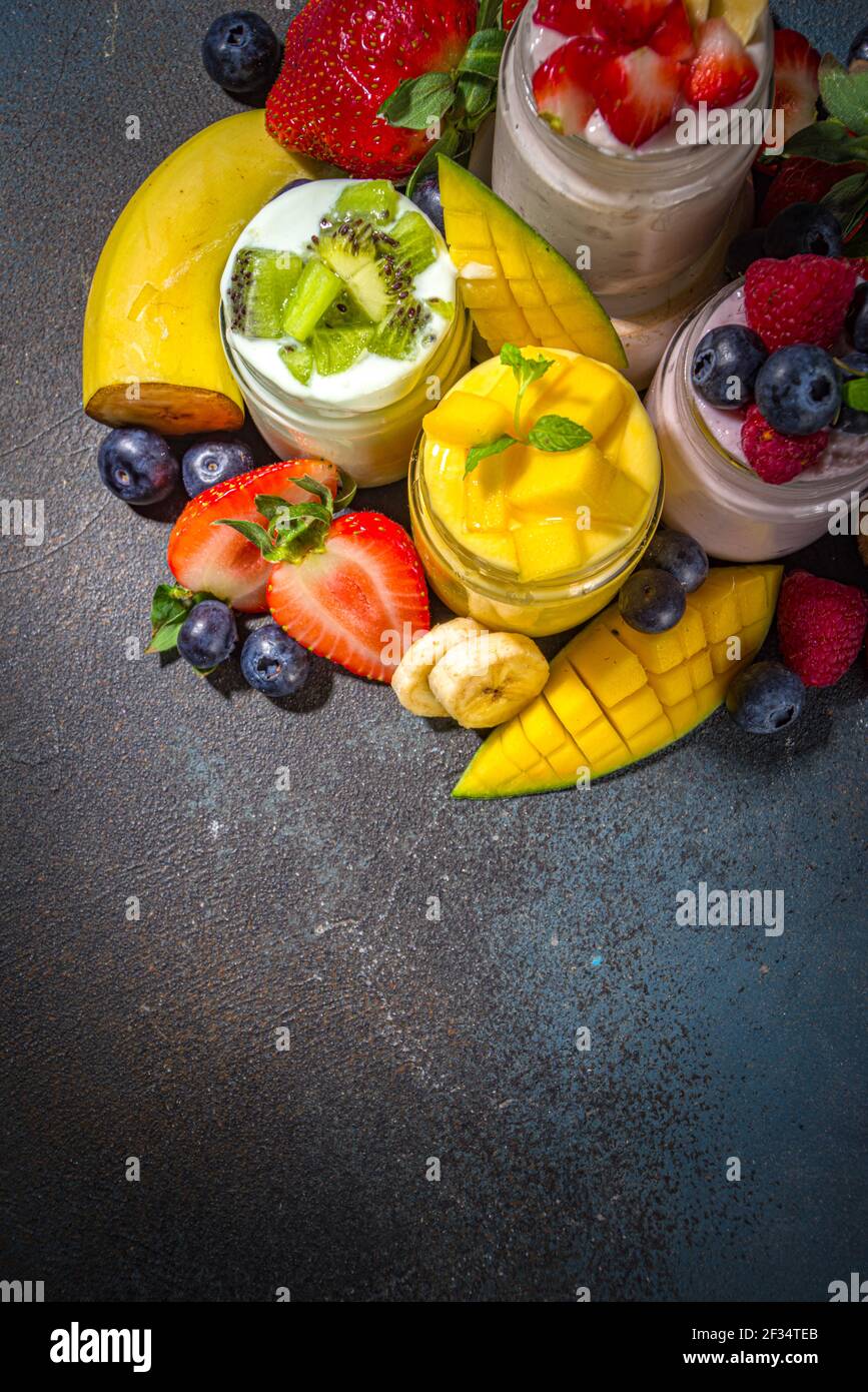 Set of various fruit and berry sweet yogurts in glass jars. Variety ...