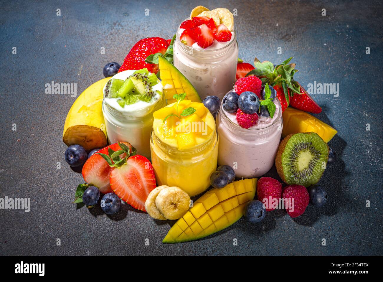 Set of various fruit and berry sweet yogurts in glass jars. Variety ...