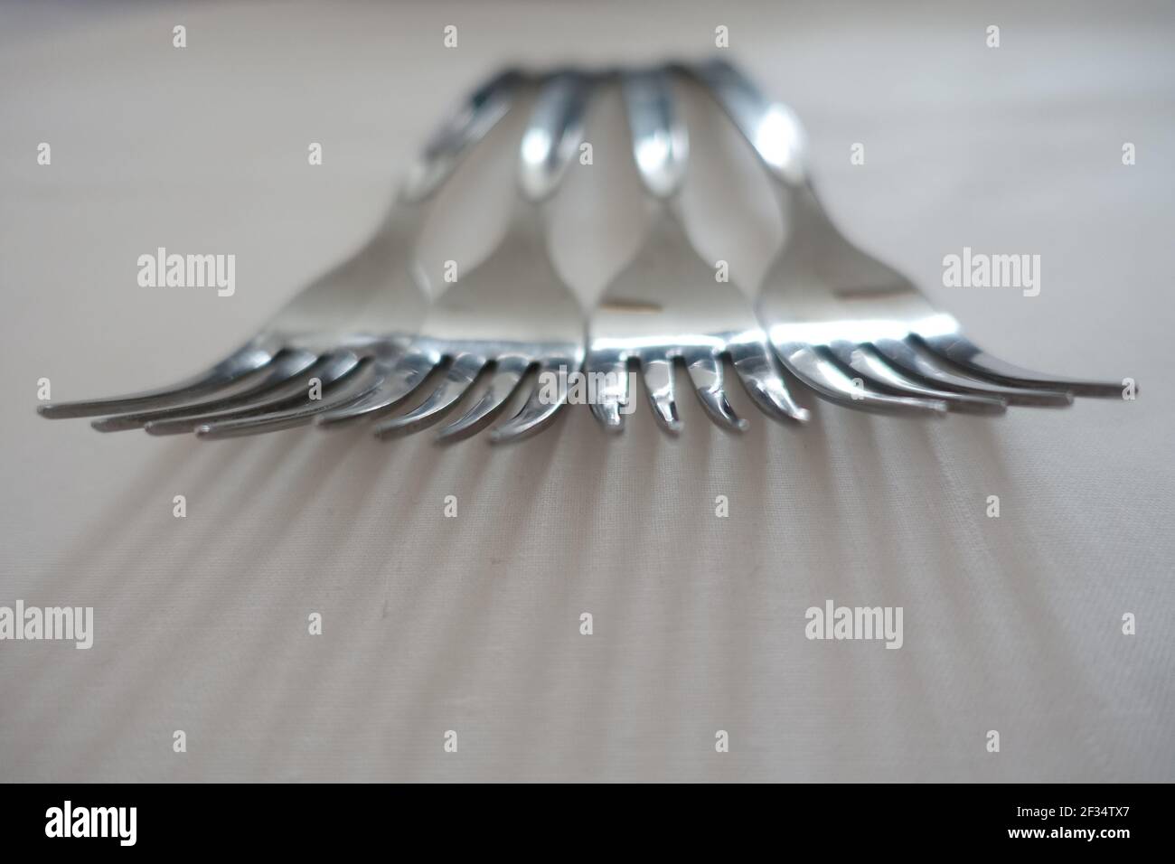 four forks on a white surface Stock Photo - Alamy