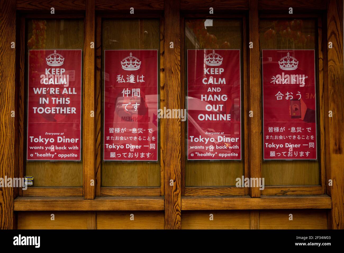 A sign in English and Chinese on a window of closed food restaurant in ...