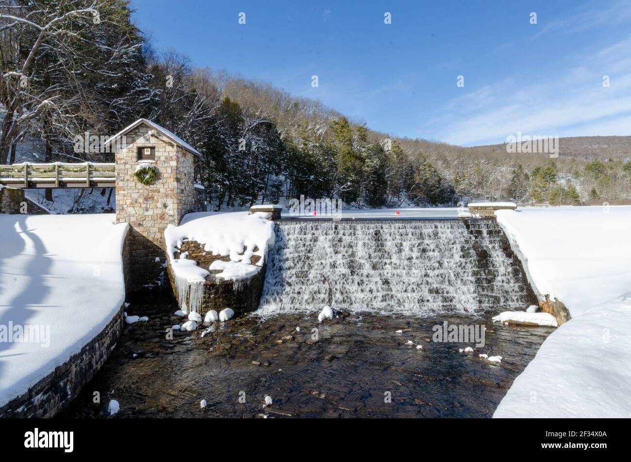 water flowing over a spillway on a snow covered dam at a state park ...