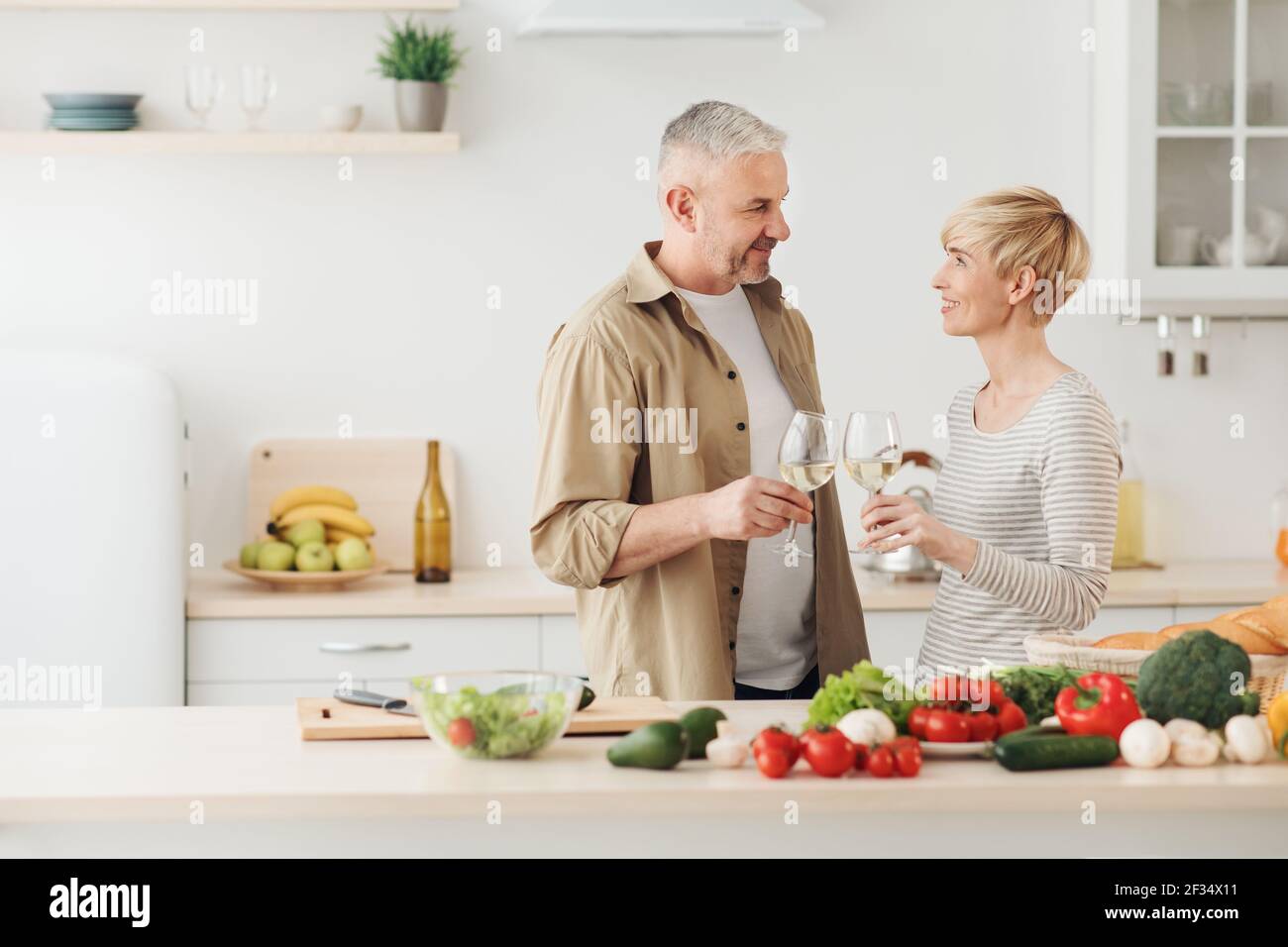 Happy husband and wife enjoying weekend, drinking wine and celebrate at ...