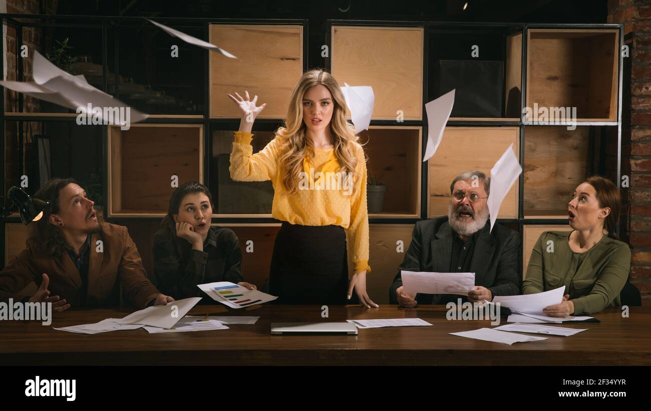 Flying sheets. Young colleagues working together in a office styled ...