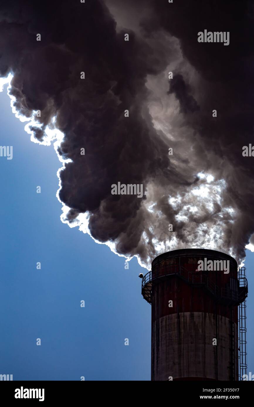 A close-up of the smoking chimneys of a coal-fired power plant. Made in ...