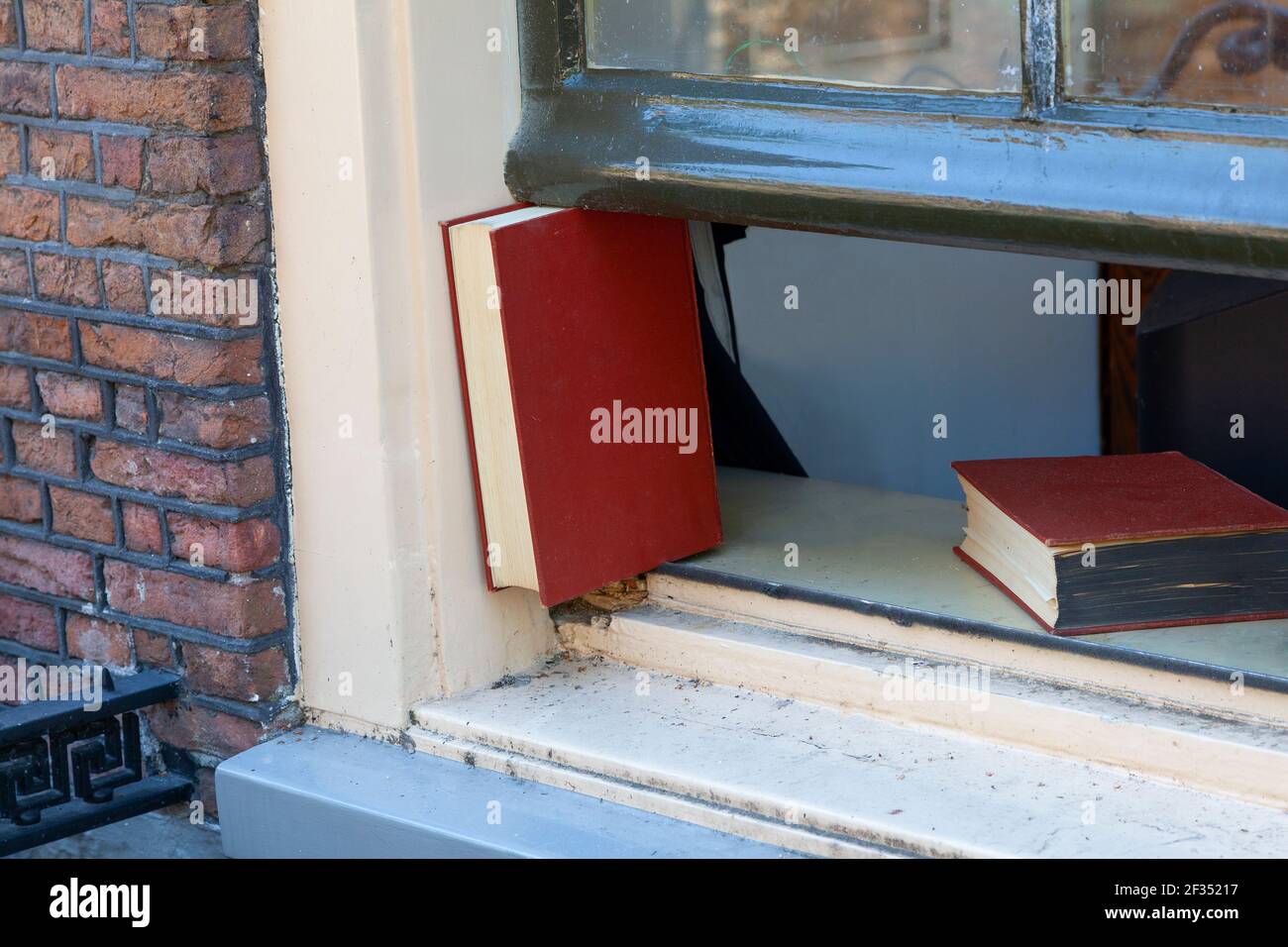 Second use of an old book to keep the window open close up Stock Photo ...
