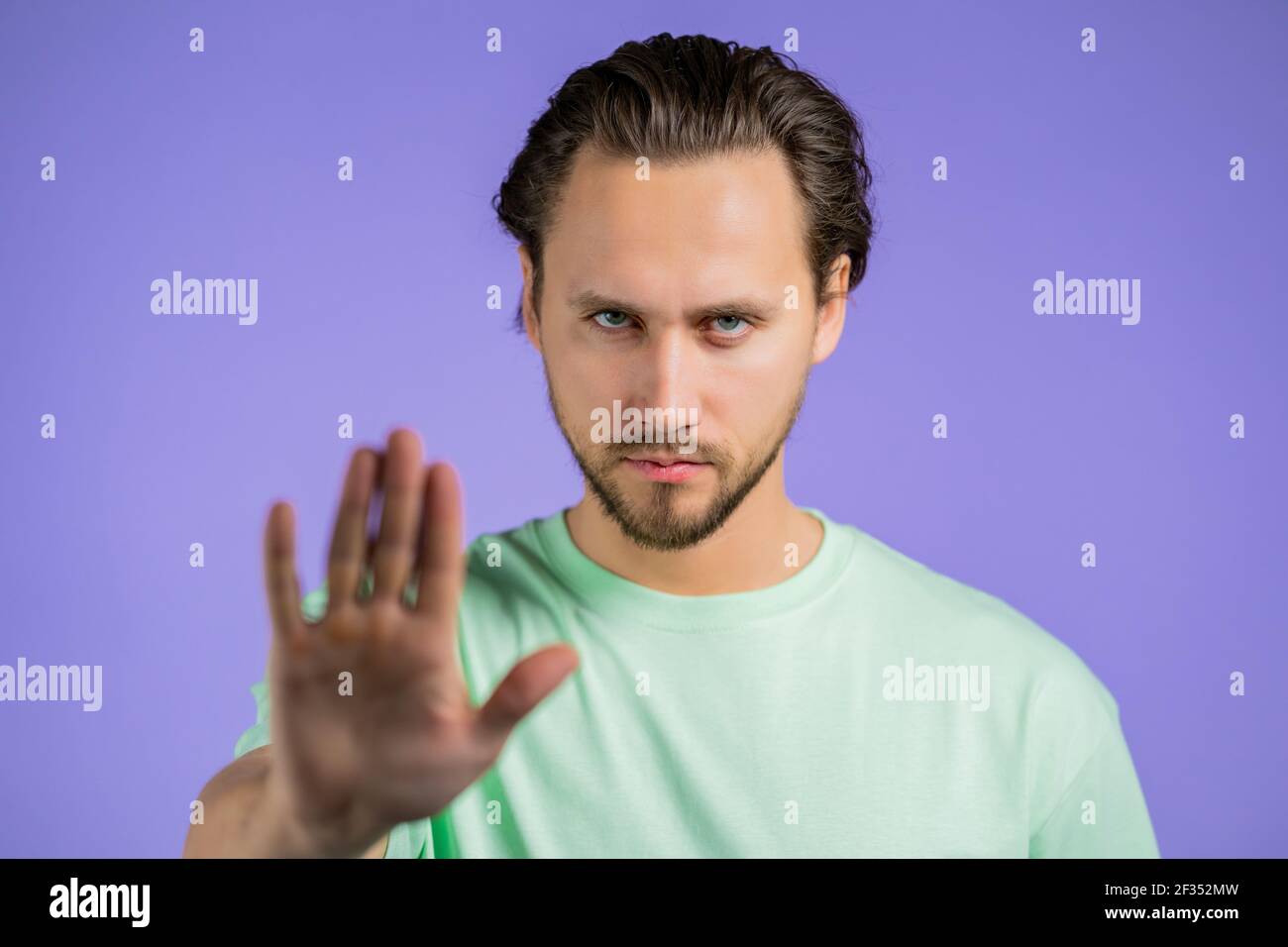Portrait of serious man disapproving with no palm hand sign make basta ...