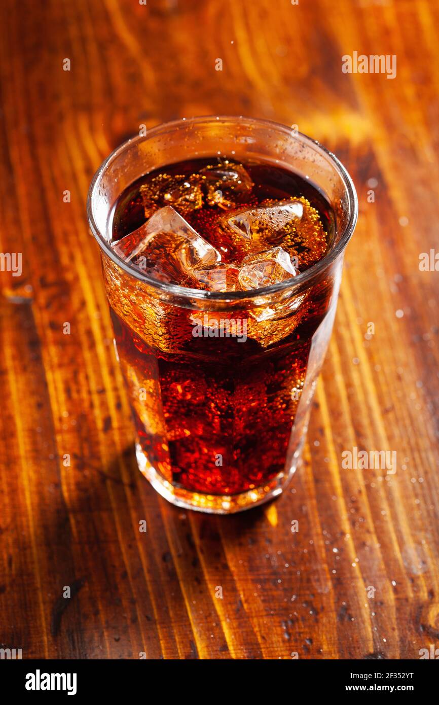 glass of cold cola soft drink with ice on wooden background Stock Photo ...