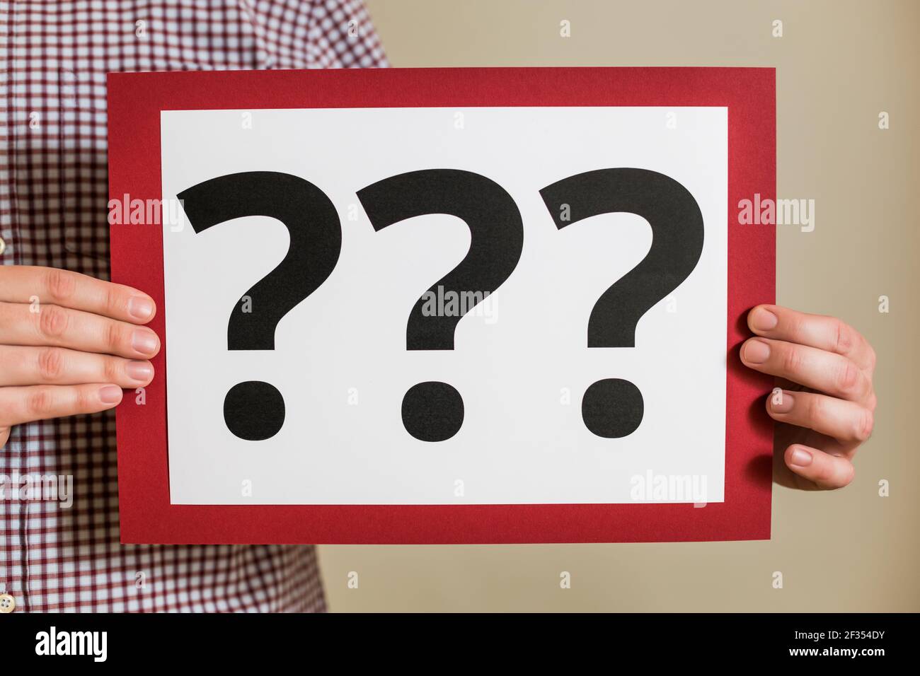 Man showing paper with question marks Stock Photo - Alamy