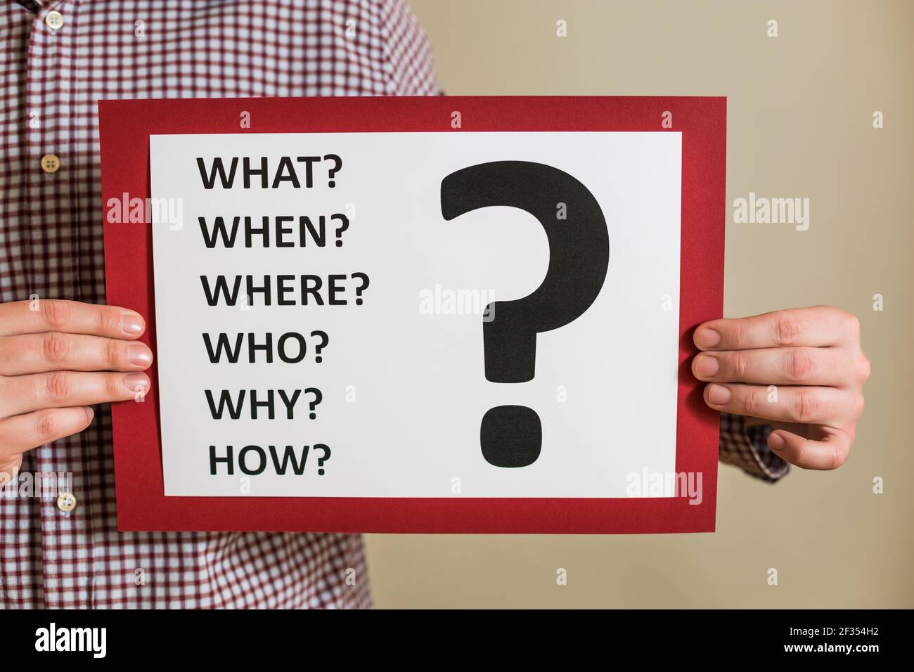 Image of man holding paper with question mark and various questions ...