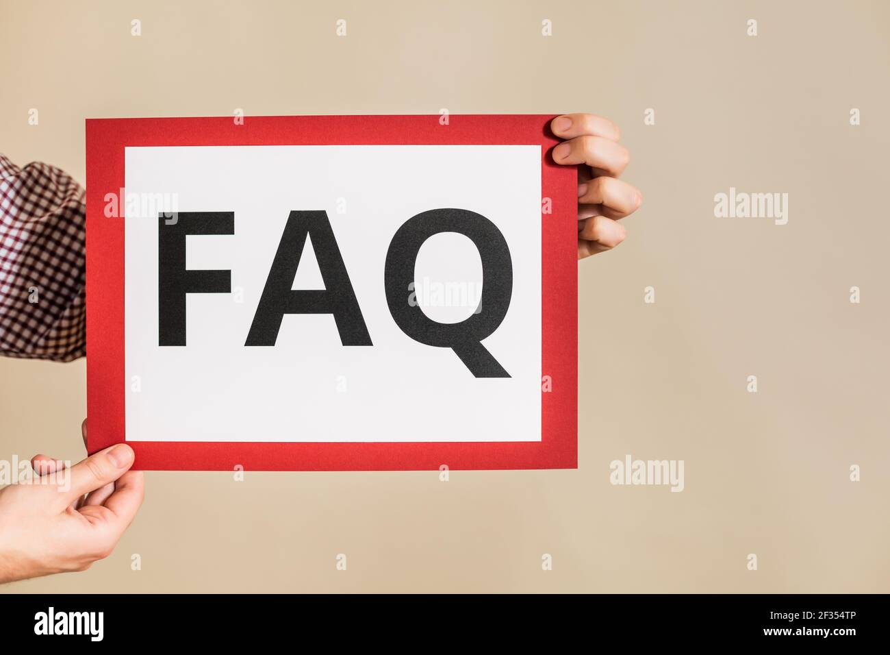Image of man holding paper with text FAQ Stock Photo - Alamy