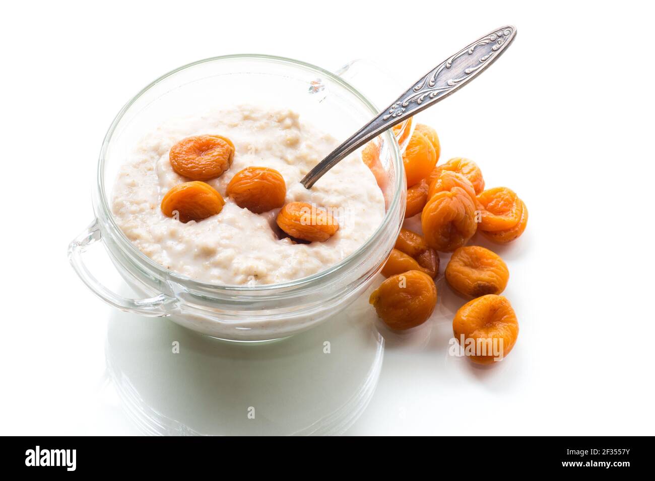 cooked boiled sweet oatmeal with dried apricots in a bowl isolated on ...