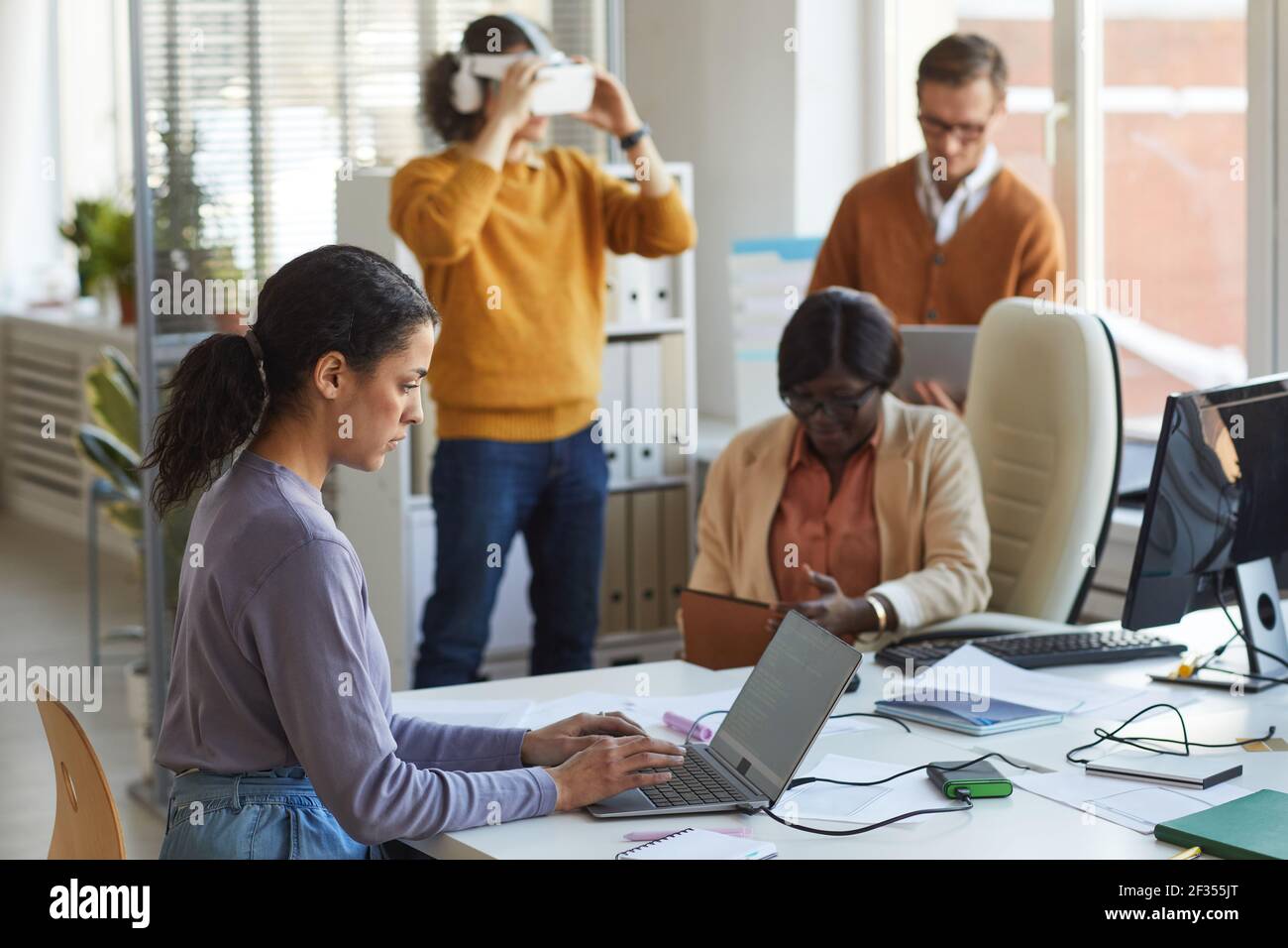 Side view portrait of female IT developer using laptop with code on ...
