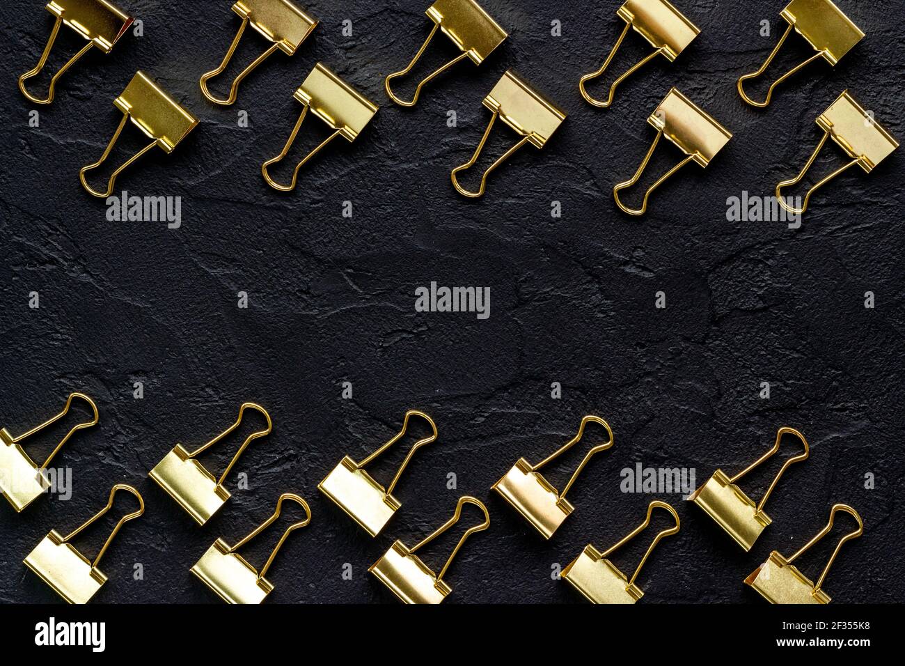 Frame of stationery golden paper binder clips top view. Office supplies ...